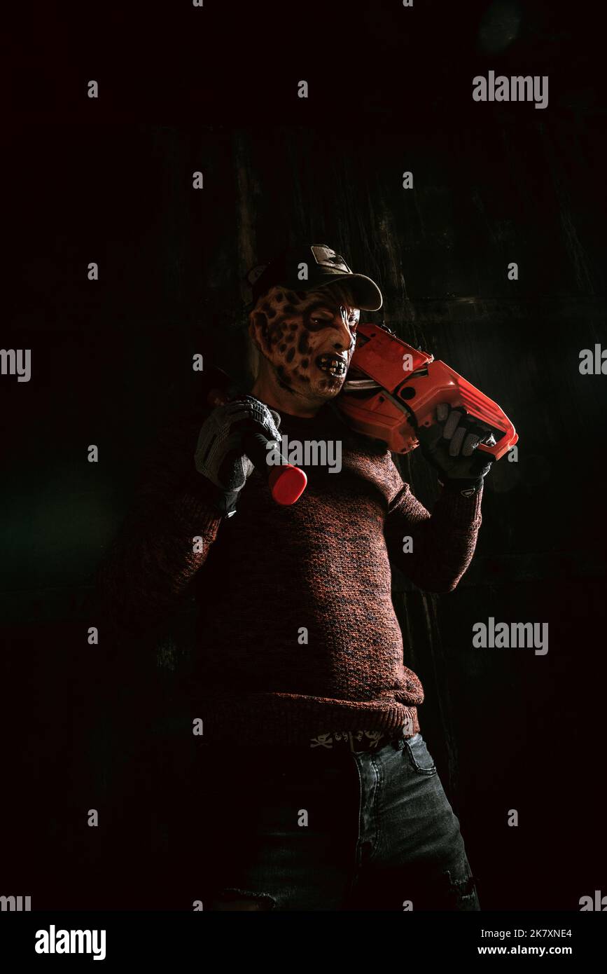 Evil in mask with chainsaw, horror Halloween scene in dark room Stock ...
