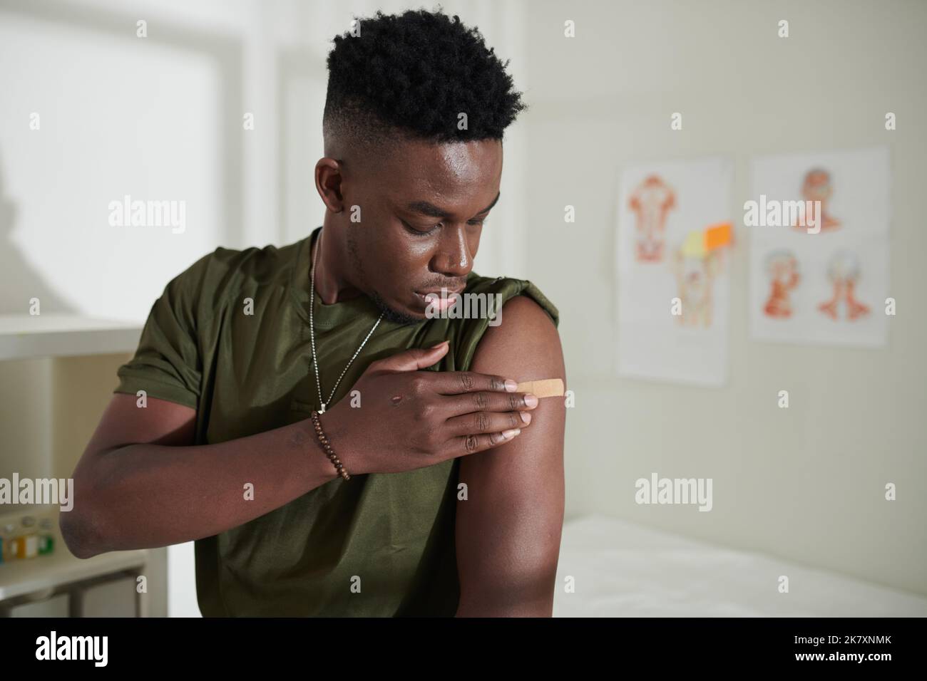 Young soldier covering injection site with band aid to protect from ...