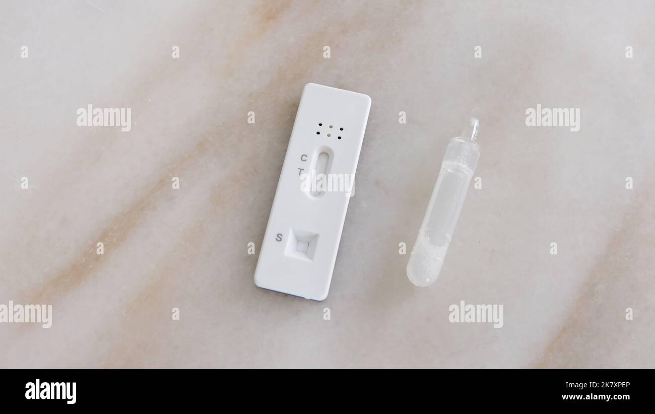 A home testing kit with the container holding the sample liquid next to ...