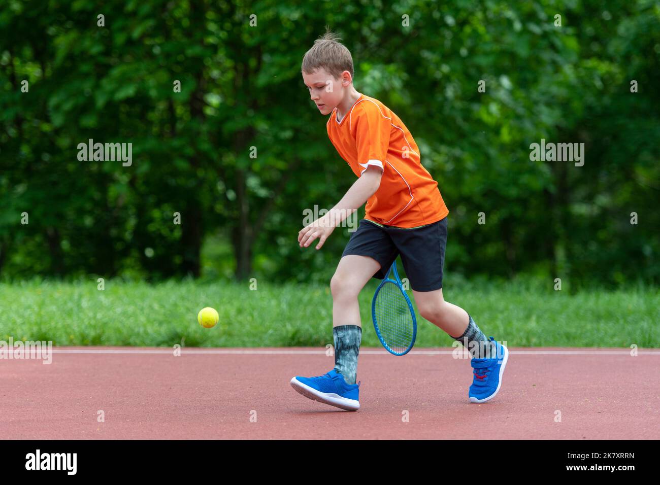 Child with tennis racket on tennis court. Training for young kid ...