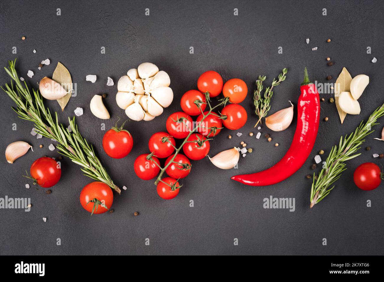 Food background - many seasonings, herbs and vegetables over dark ...