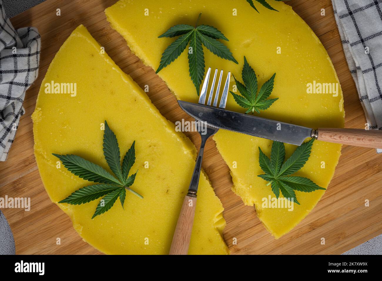 Yelllow marijuana butter on light stone table with dish towel and color ...