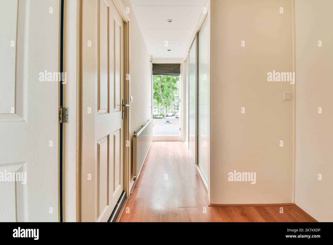 Light narrow hallway with many doors in white walls and glowing lamp ...