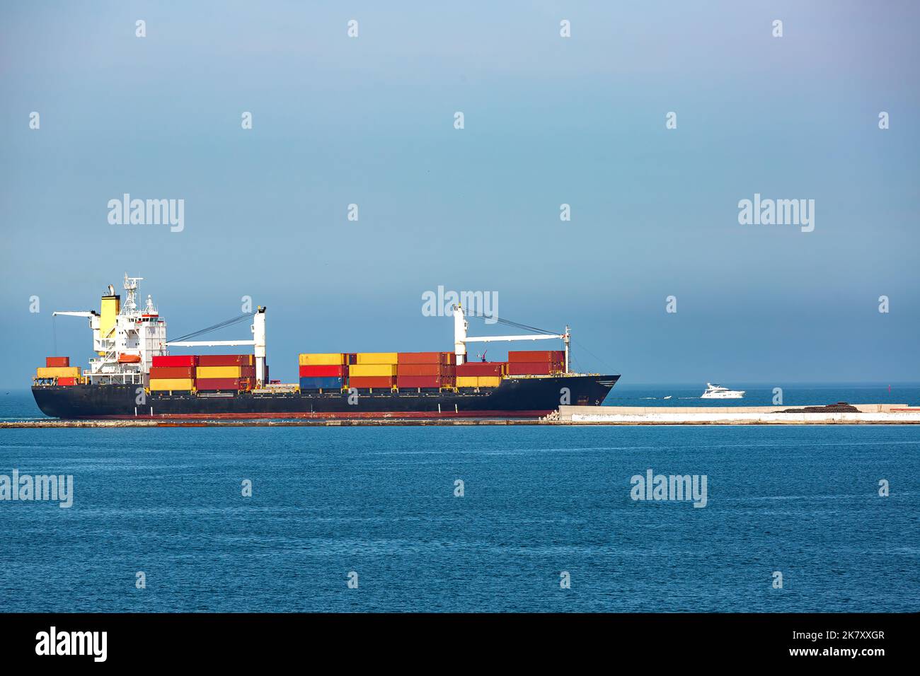 a bulk carrier with cranes for unloading cargo transports multi-colored ...