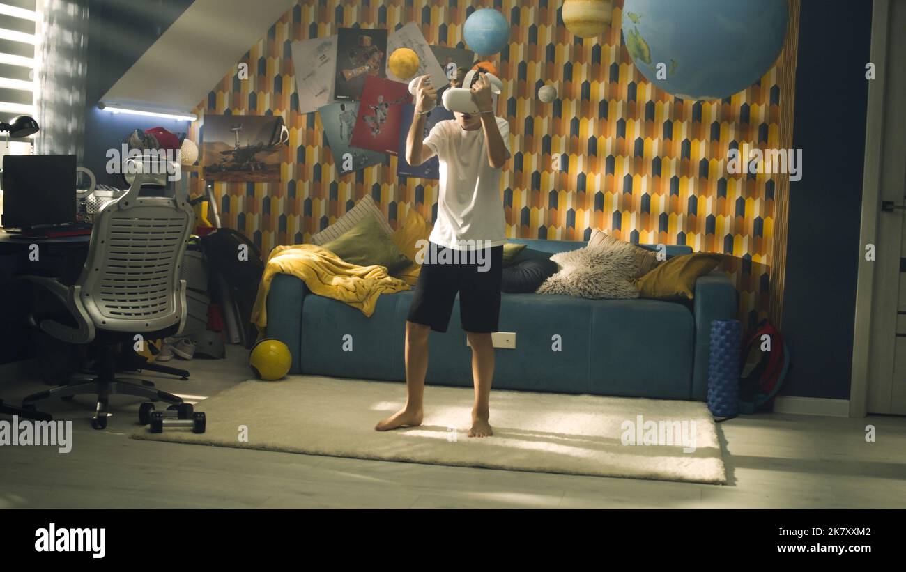 Teenage boy plays a boxing game wearing virtual reality headset and ...