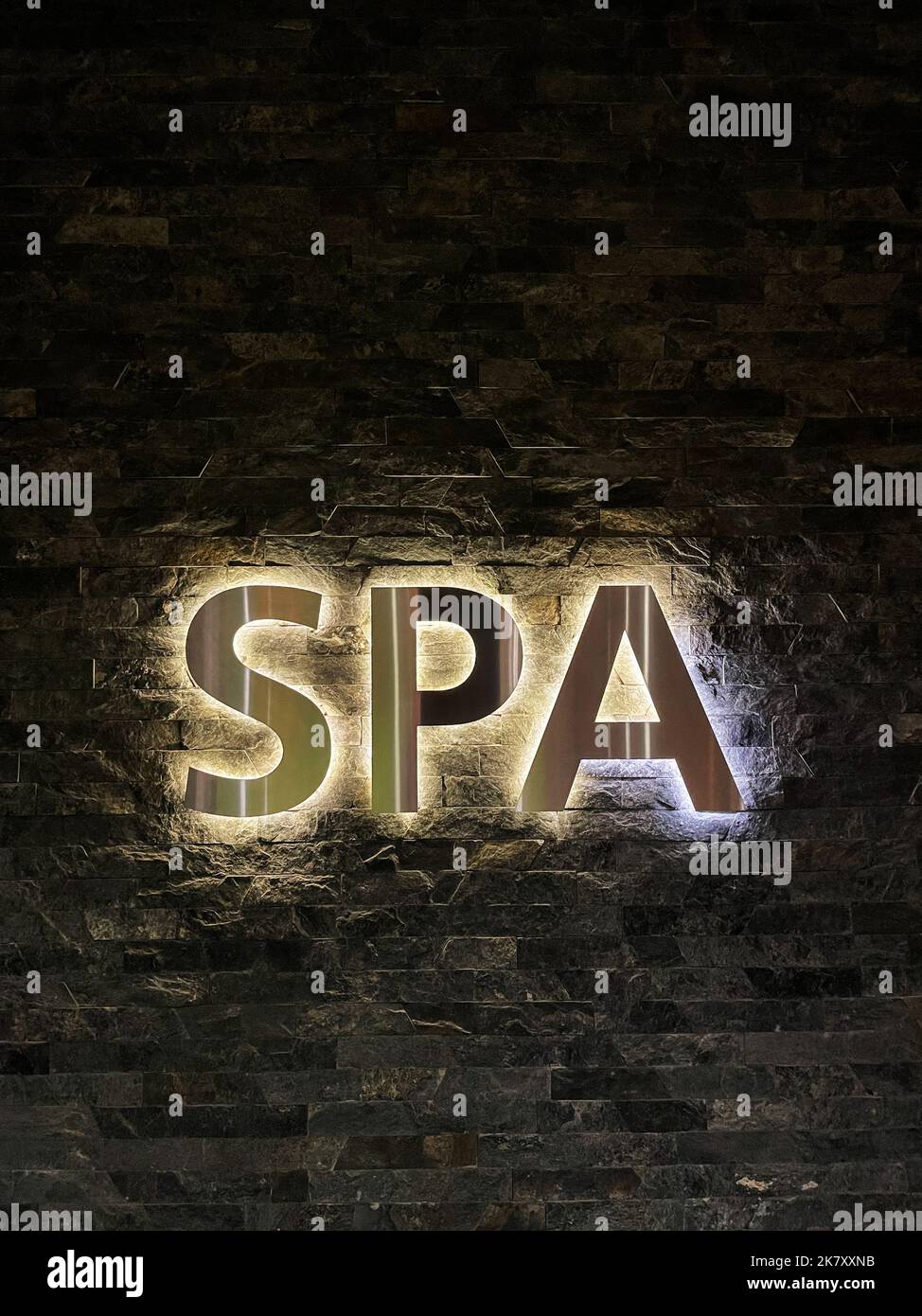 Advertising sign spa area on a black brick wall Stock Photo - Alamy