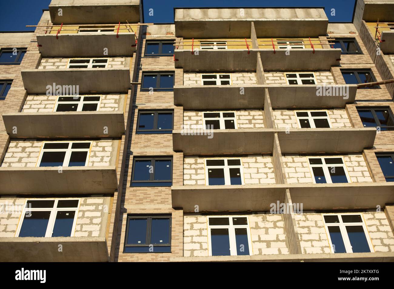 Facade of building. Unfinished house. Windows in new multi-storey ...