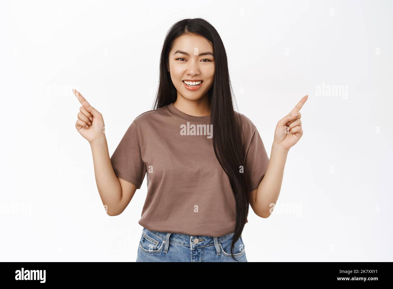 Portrait of beautiful asian female model pointing sideways, showing two ...