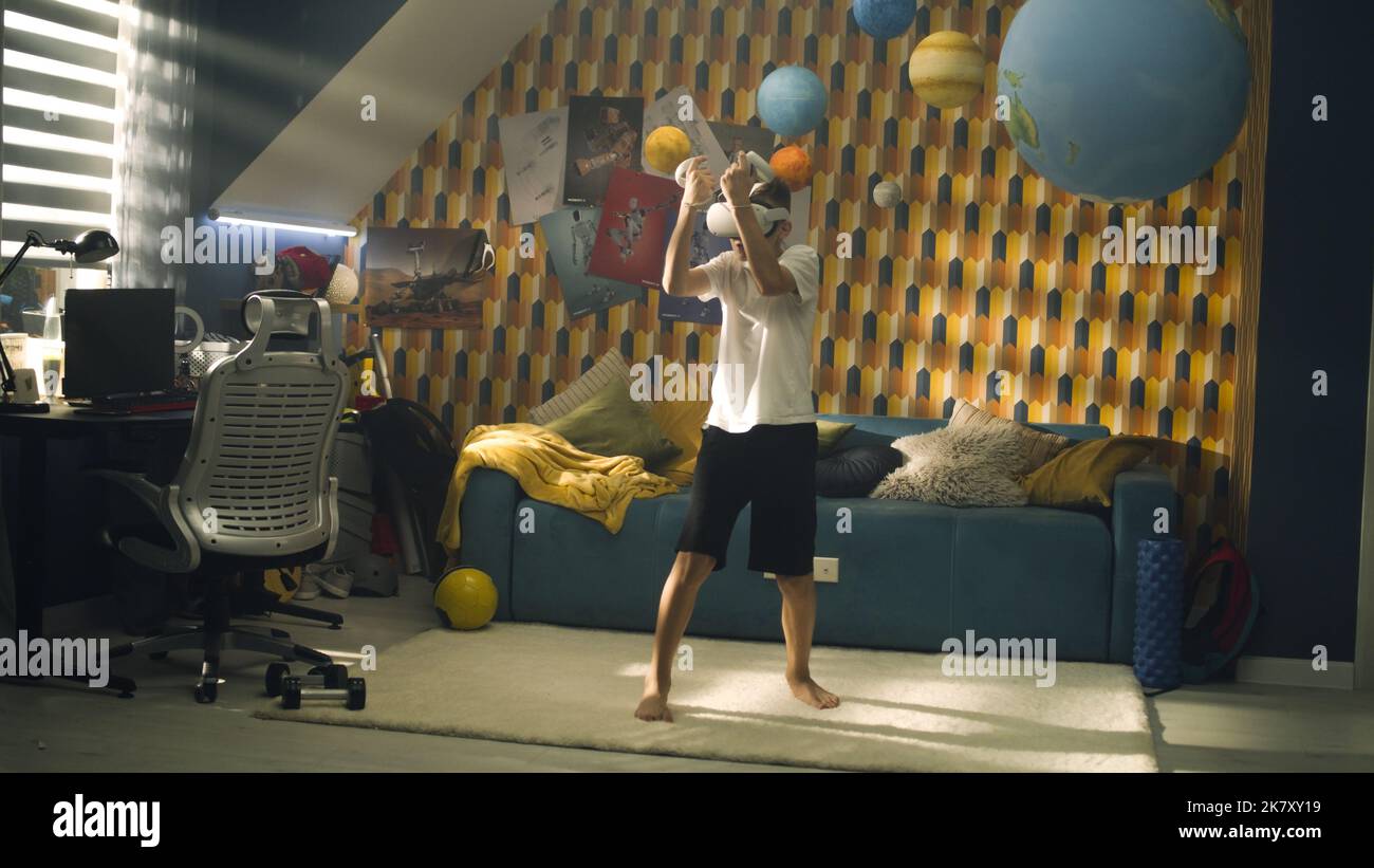 Teenage boy plays a boxing game wearing virtual reality headset and ...