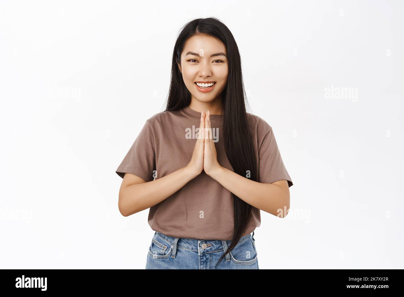 Smiling asian woman praying, holding hands in namaste, thank you ...
