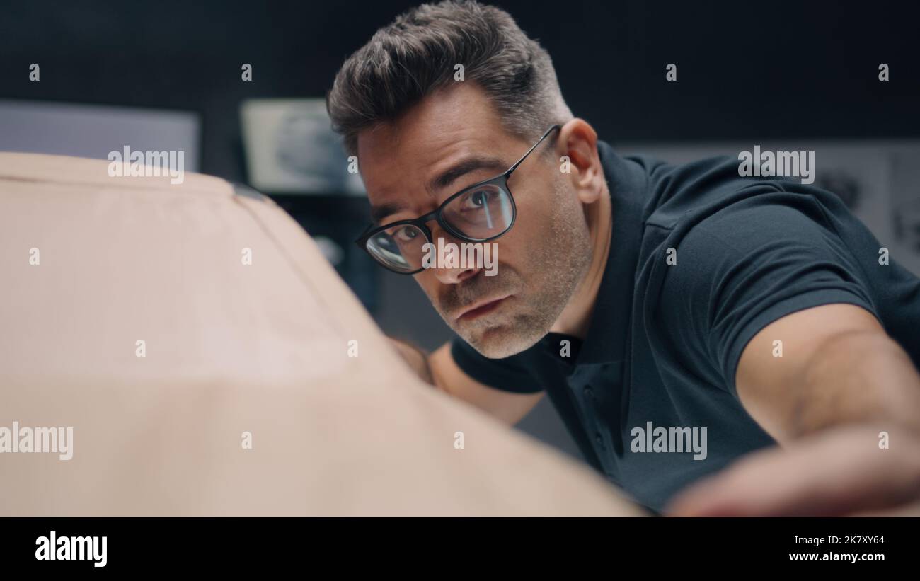 Male middle aged automotive designer working on futuristic car model ...