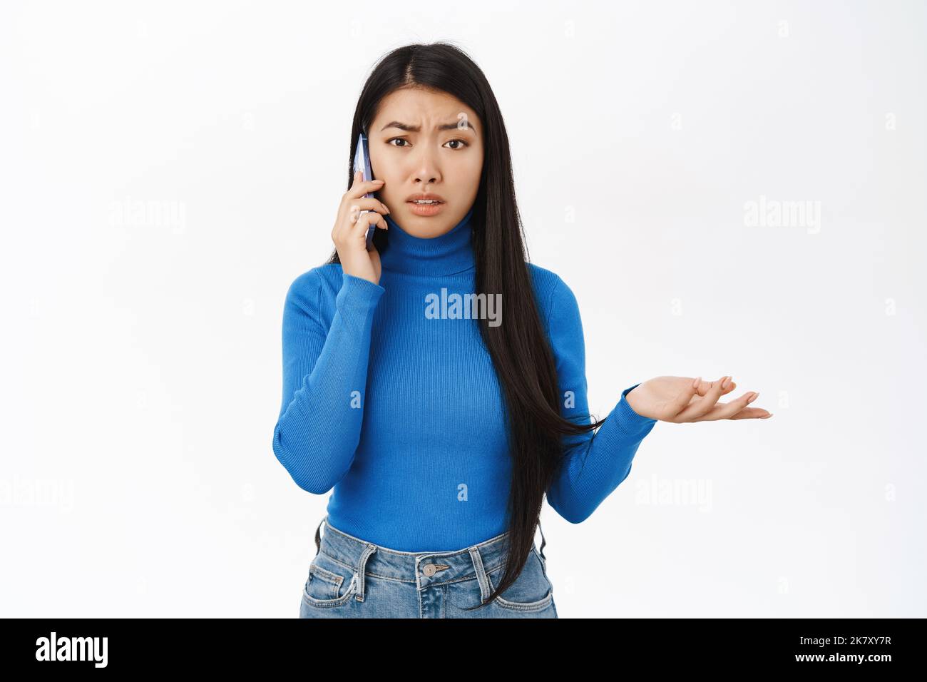 Portrait of korean woman with confused face talking on mobile phone ...