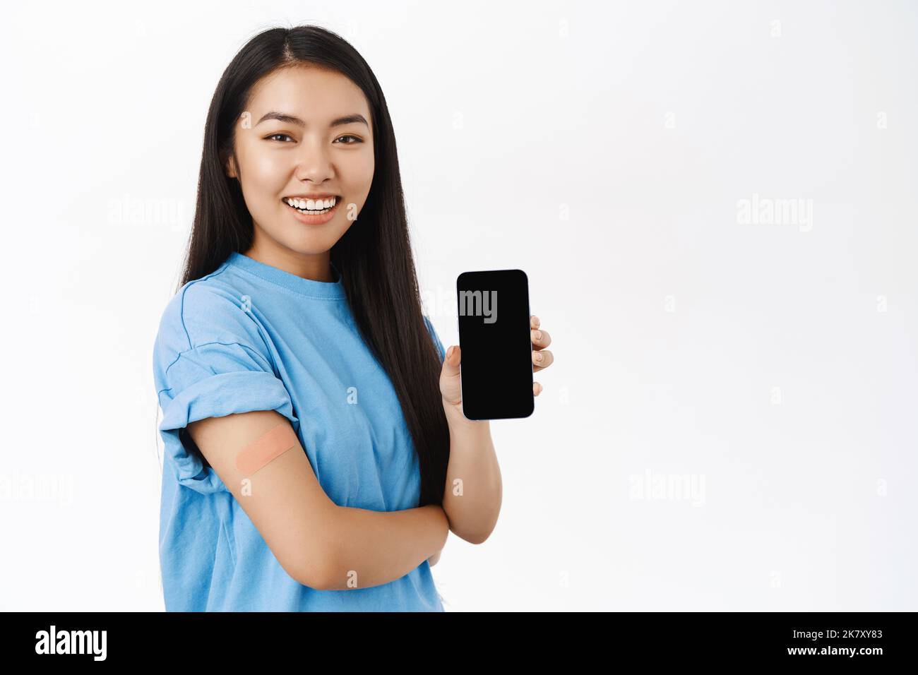 Smiling asian girl with band aid after coronavirus vaccine, shows ...