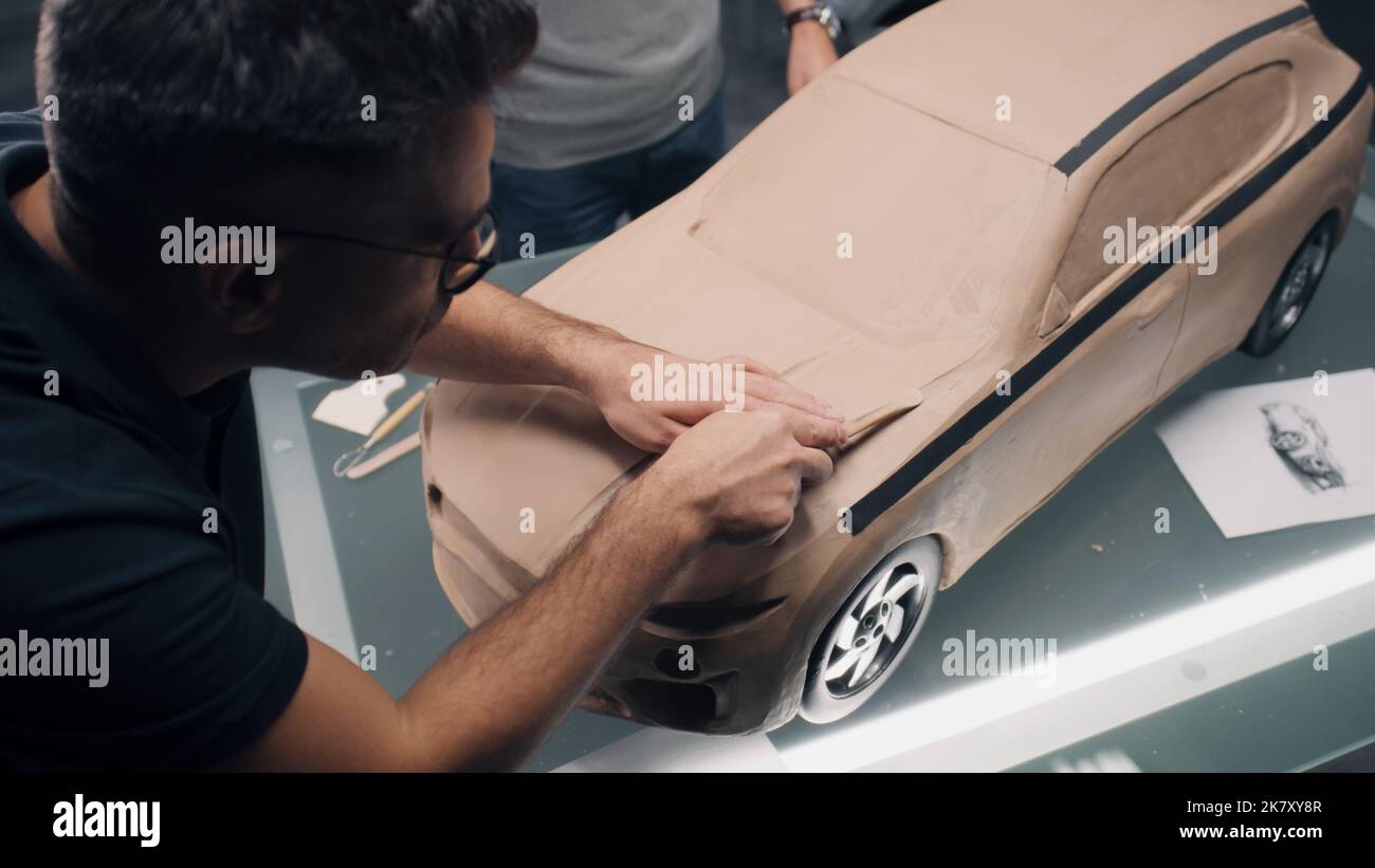 Two male automotive designers sculpting futuristic plasticine clay ...