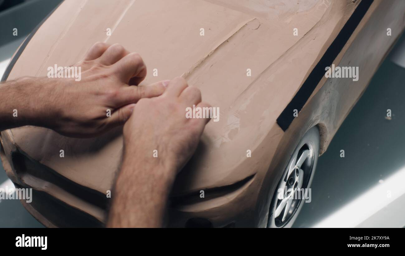 High angle shot of male automotive designer sculpting futuristic car ...