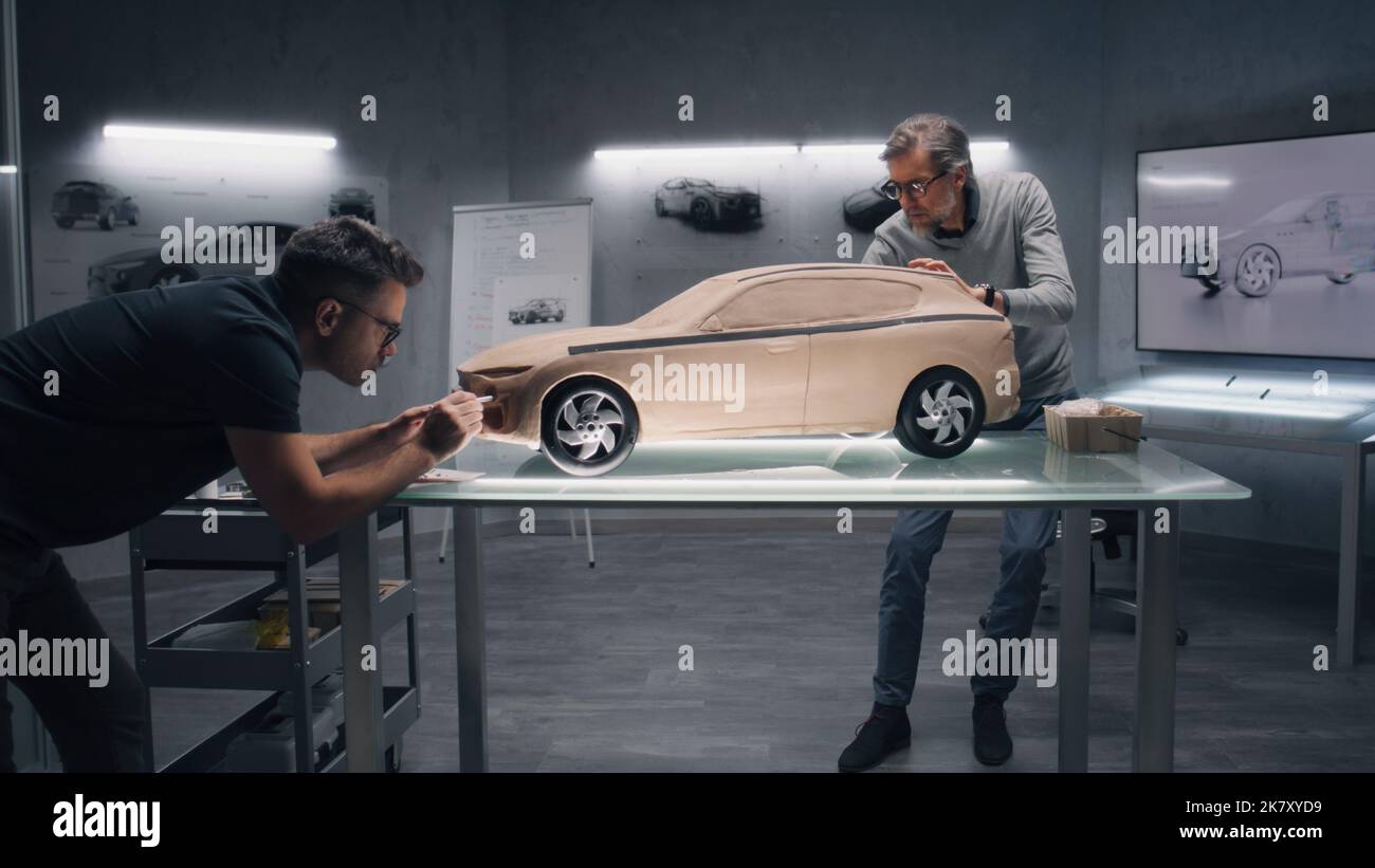 Two male automotive designers creating model of car in modern car ...