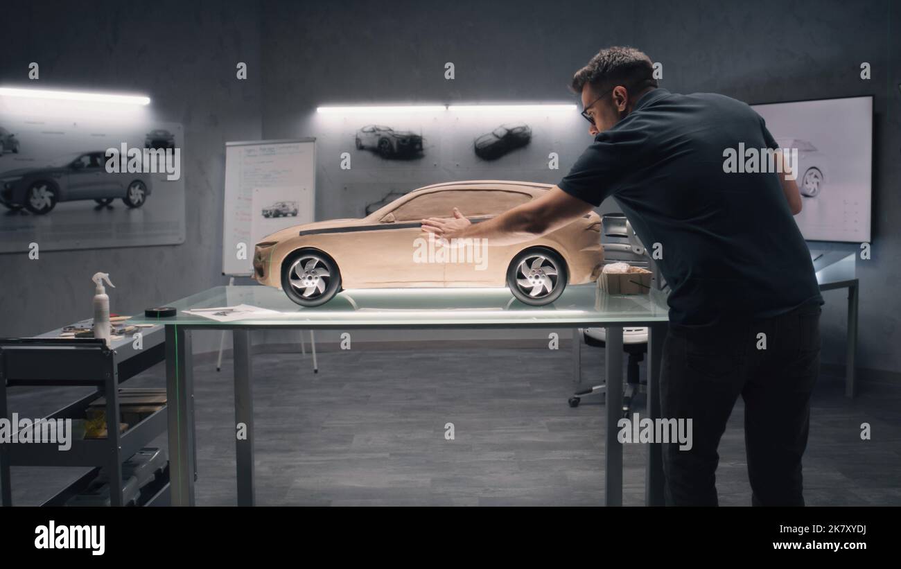 Two male automotive designers creating model of car in modern car ...