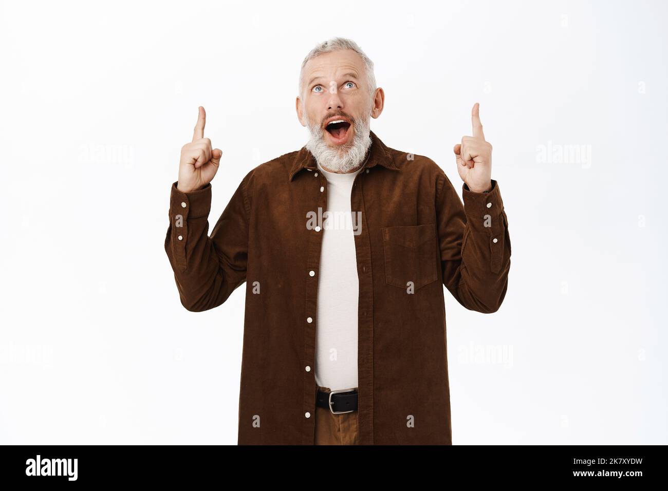 Impressed old man with beard, pointing fingers up, showing ...