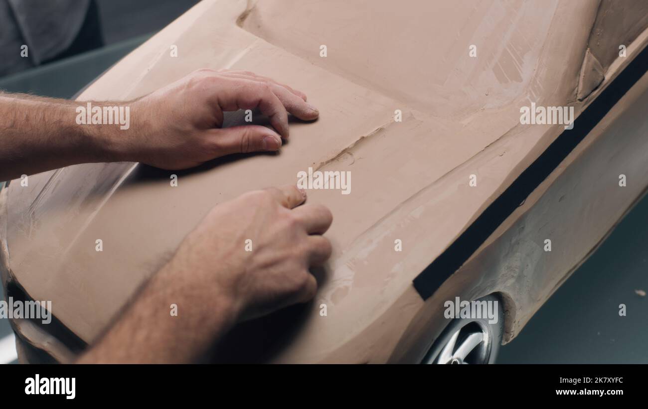 High angle shot of male automotive designer sculpting futuristic car ...