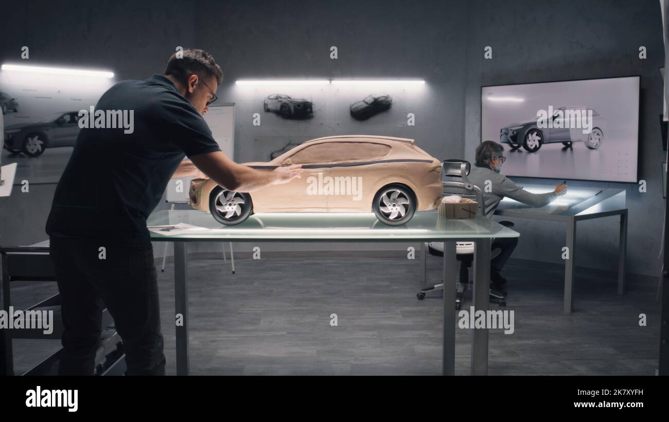 Two male automotive designers creating model of car in modern car ...