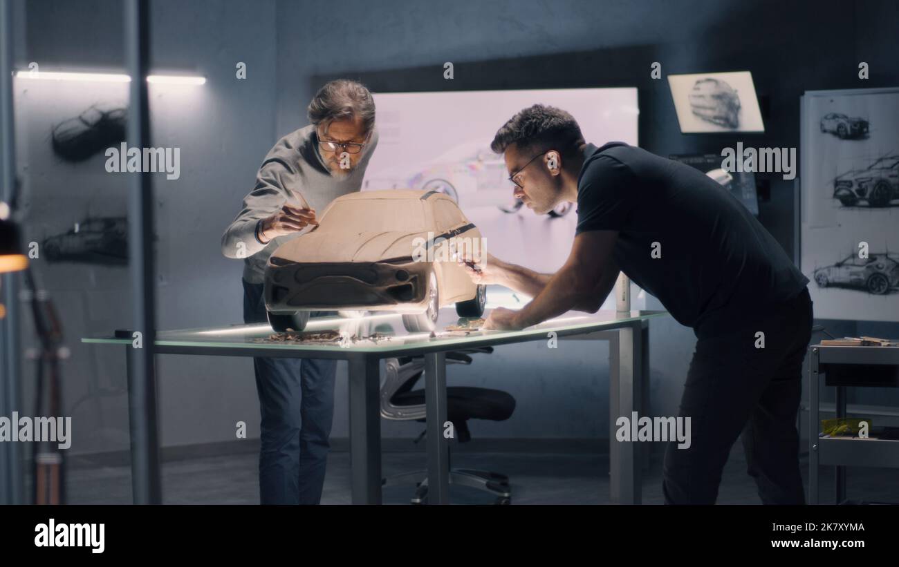 Two male automotive designers sculpting futuristic plasticine clay ...