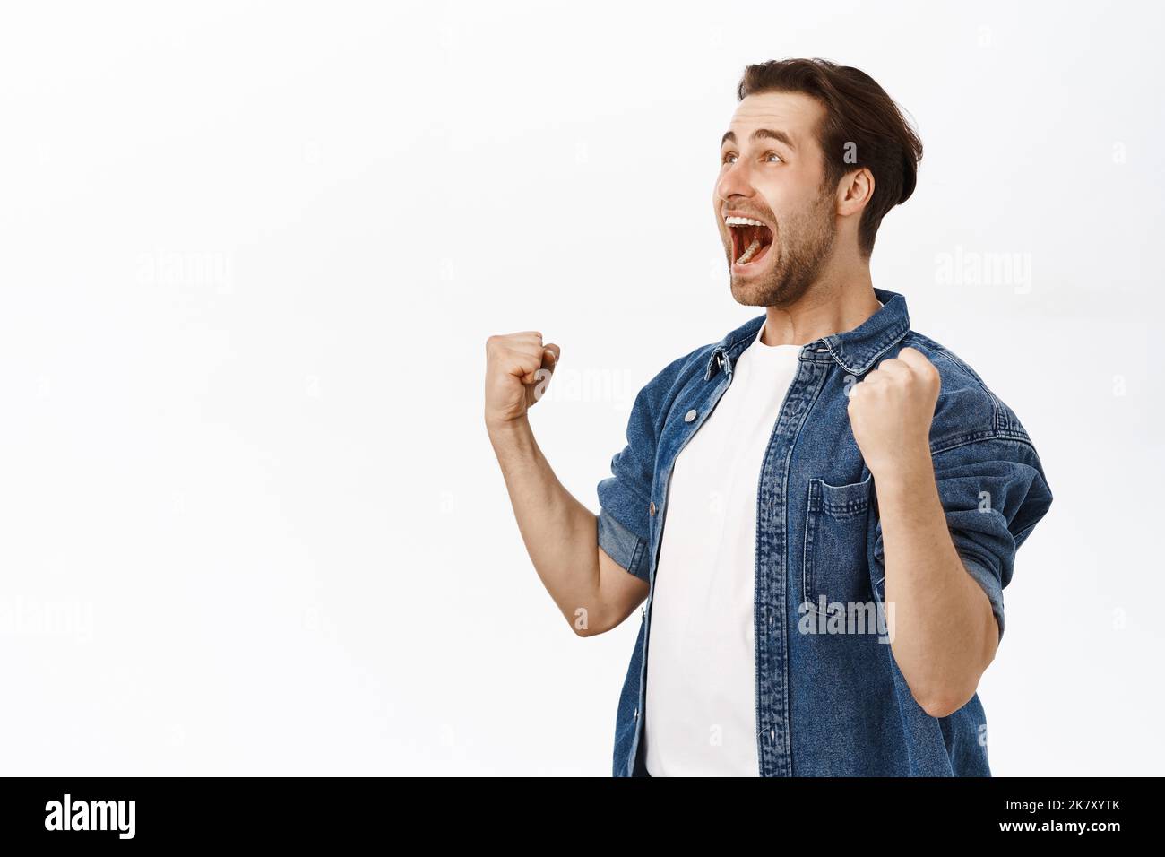 Happy guy winning, triumphing, looking at smth and celebrating victory ...