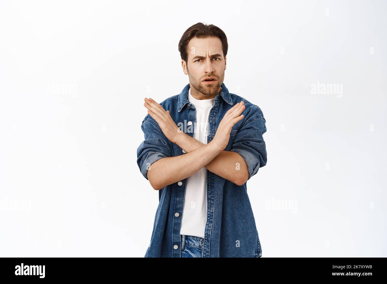 Portrait of adult man shows cross, stop sign, disapprove smth, dislike ...