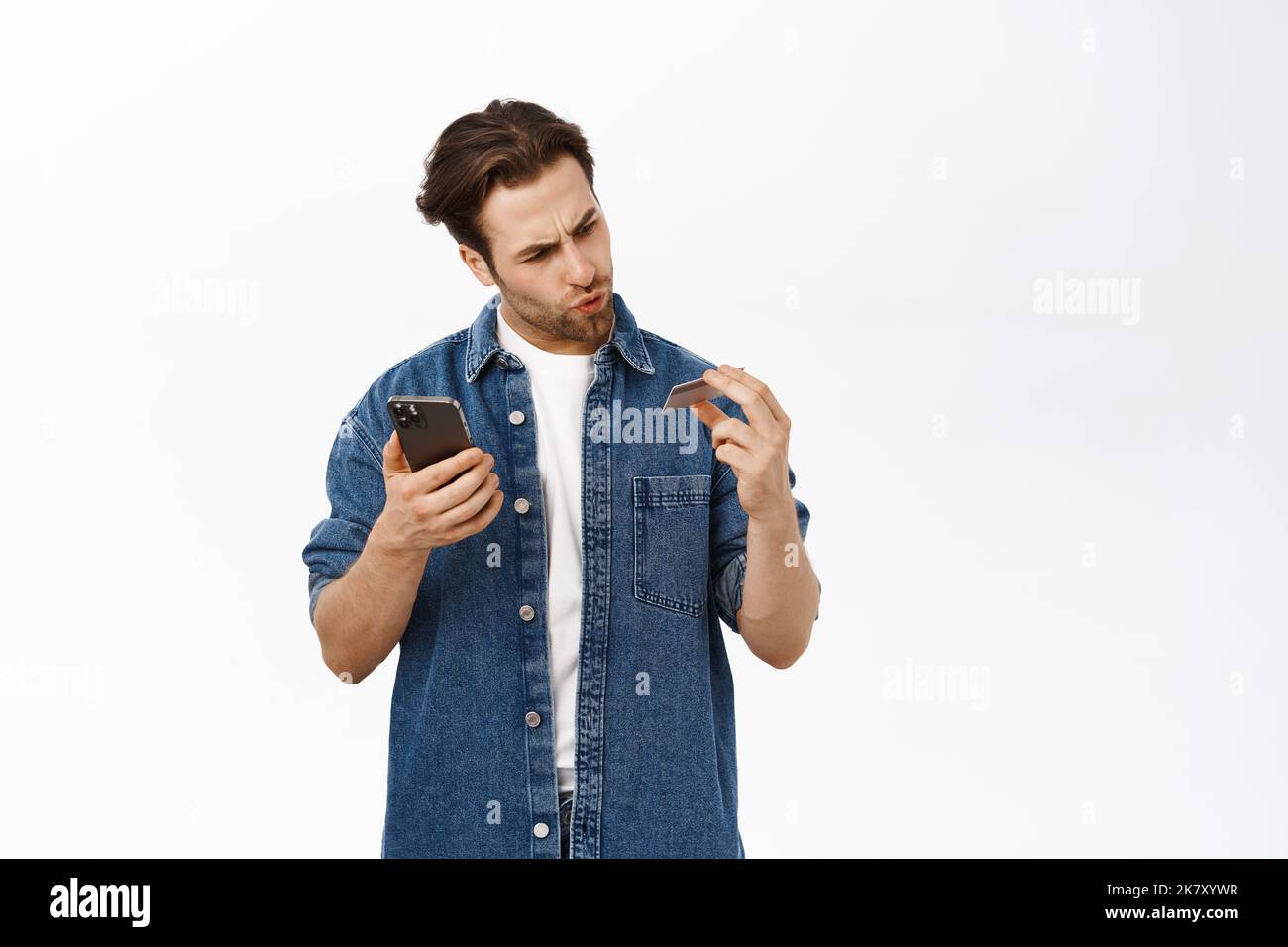 Portrait of man looking confused at his credit card, has problem paying ... Portrait of man looking confused at his credit card, has problem paying ...