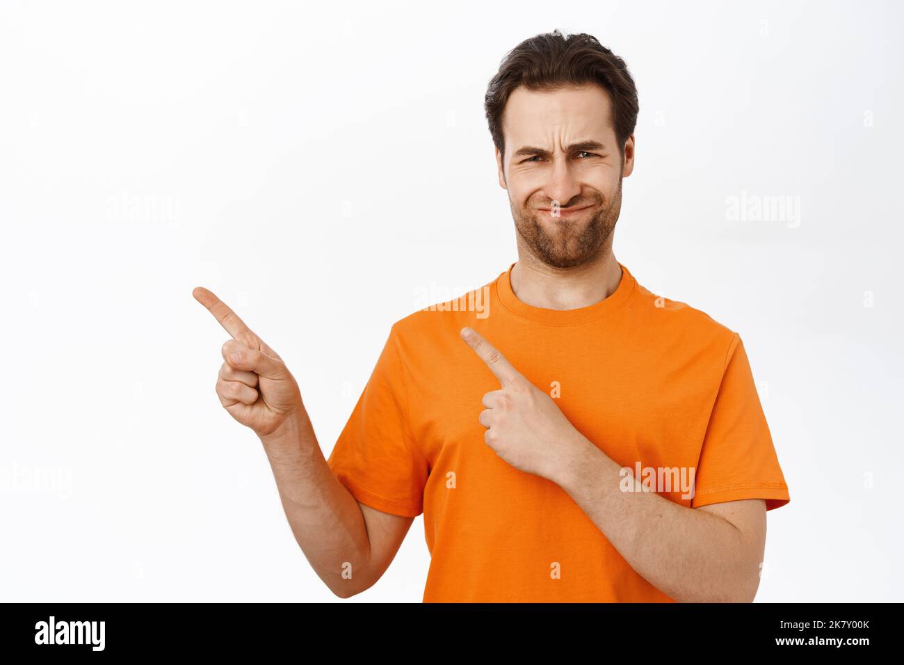 Negative emotions. Disappointed man points left, express dislike, hates ...