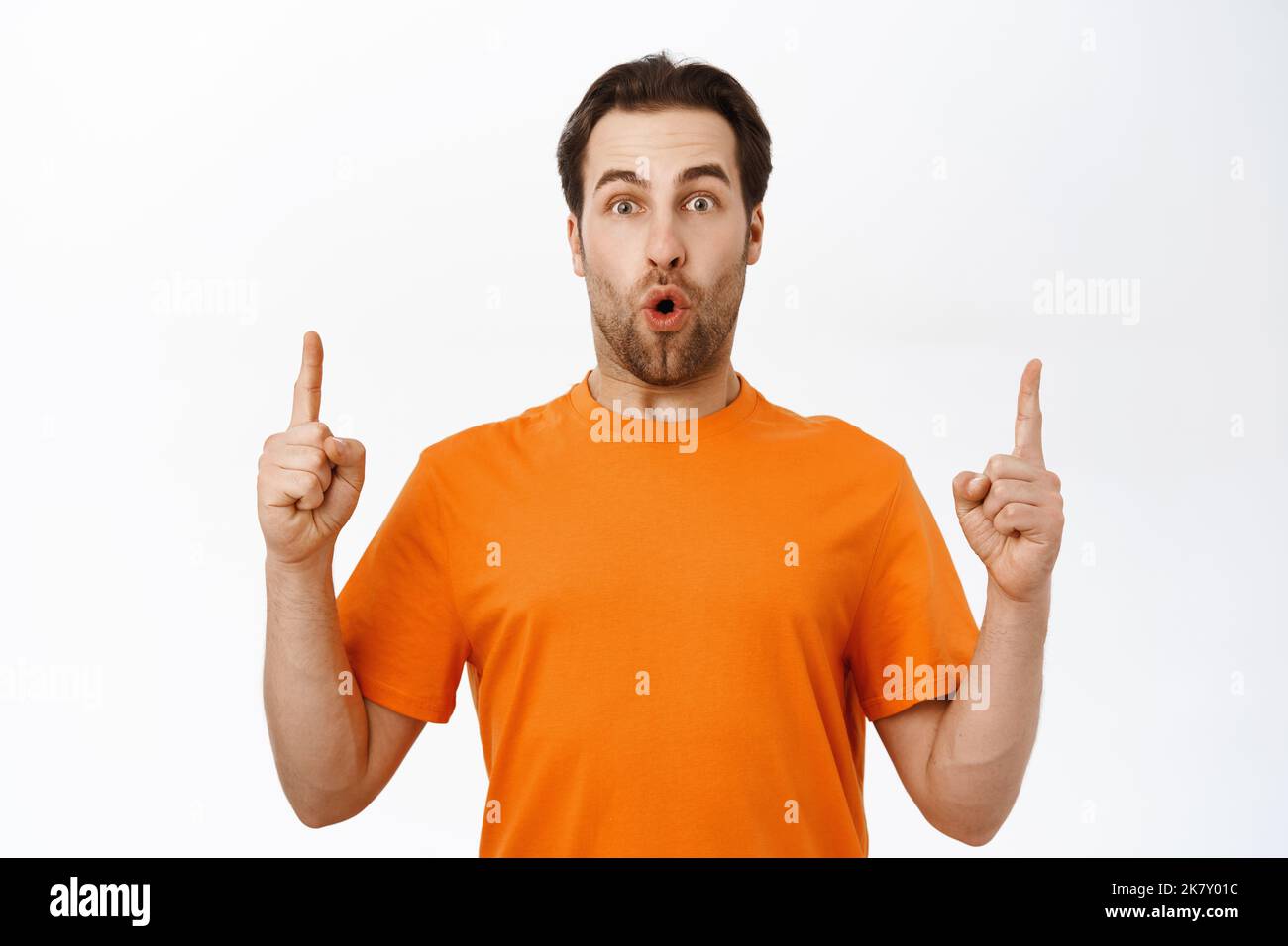 Impressed man points up, shows smth on top, making impressed face ...