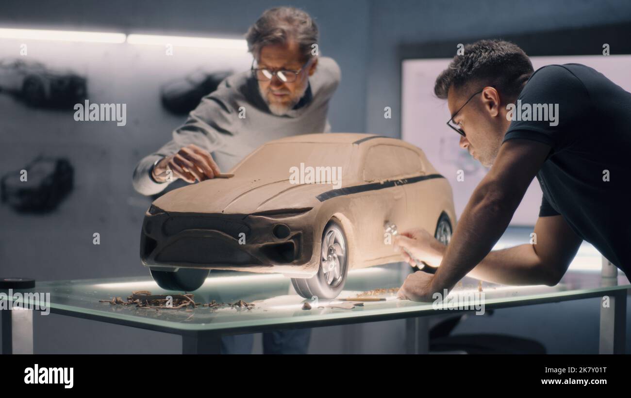 Two male automotive designers creating futuristic plasticine clay eco ...