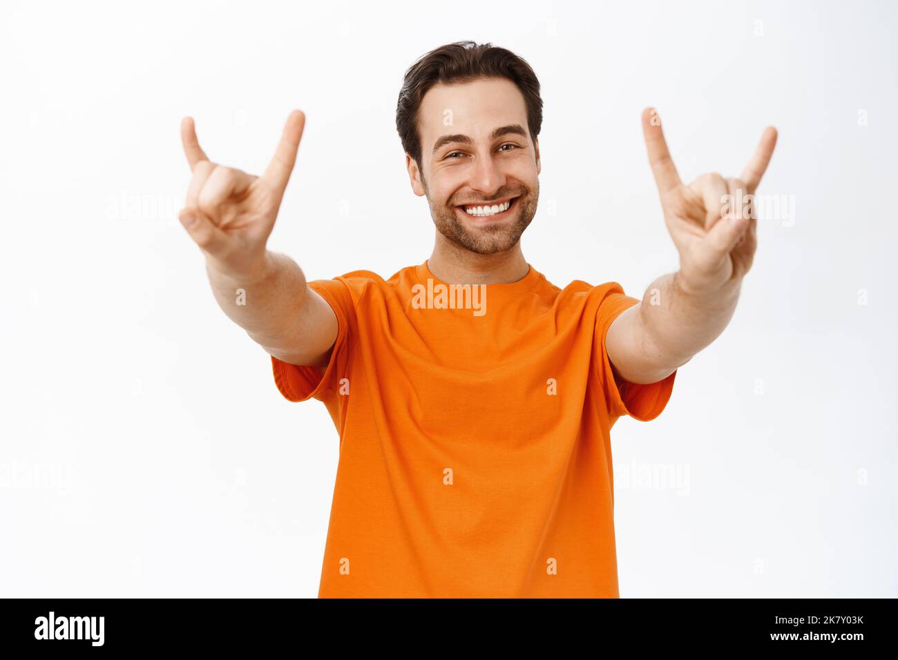 Handsome happy guy shows rock on, heavy metal sign, enjoying smth ...