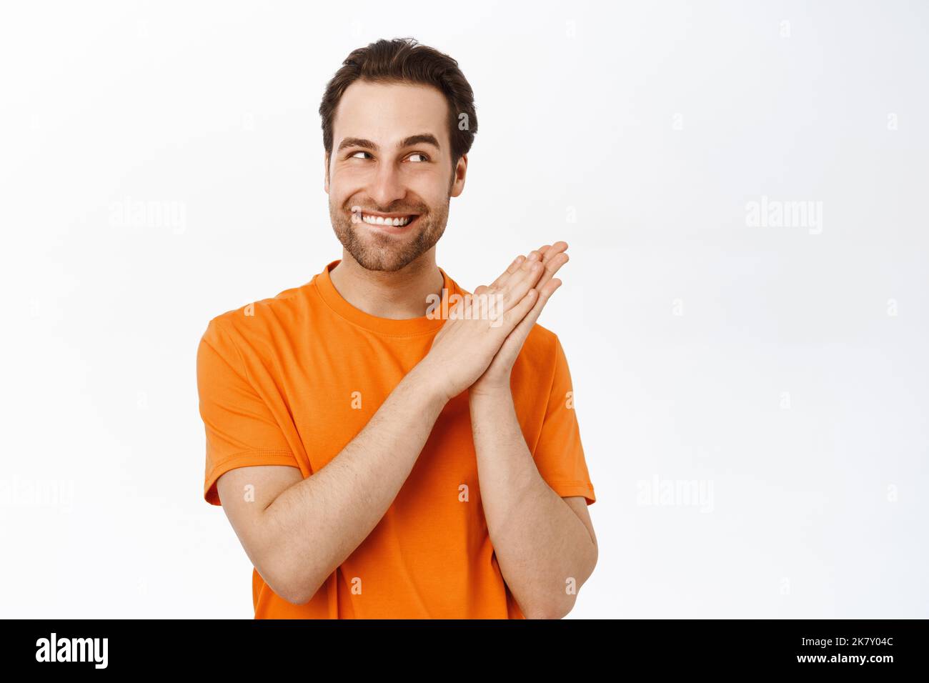 Enthusiastic smiling man rubbing hands and looking pleased, scheming ...