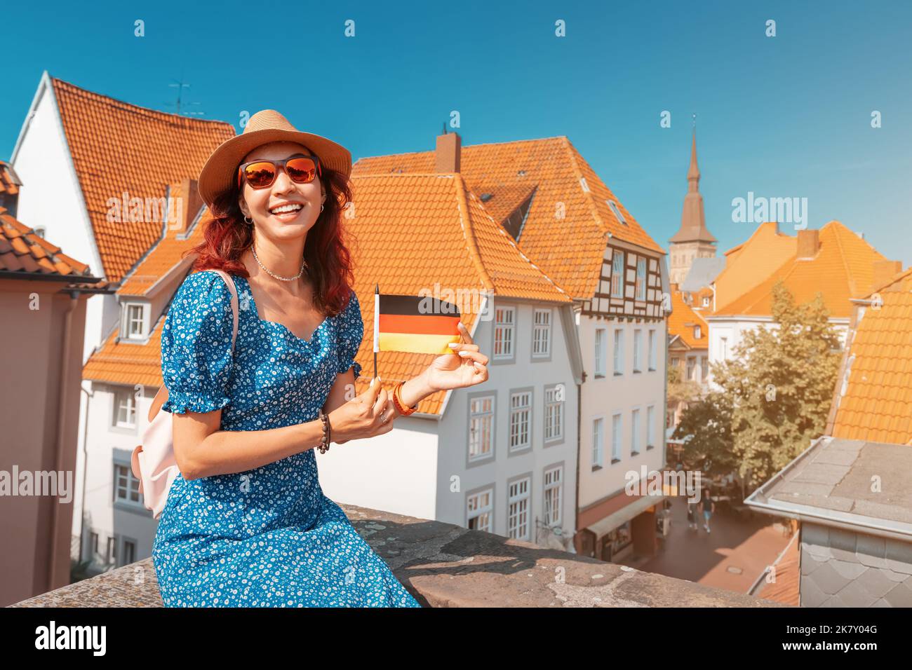 A young happy Asian girl with a German flag at the old town or Altstadt ...