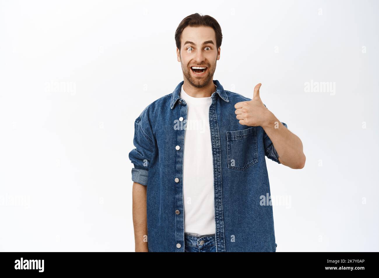 Portrait of handsome smiling man shows thumb up, approve smth ...