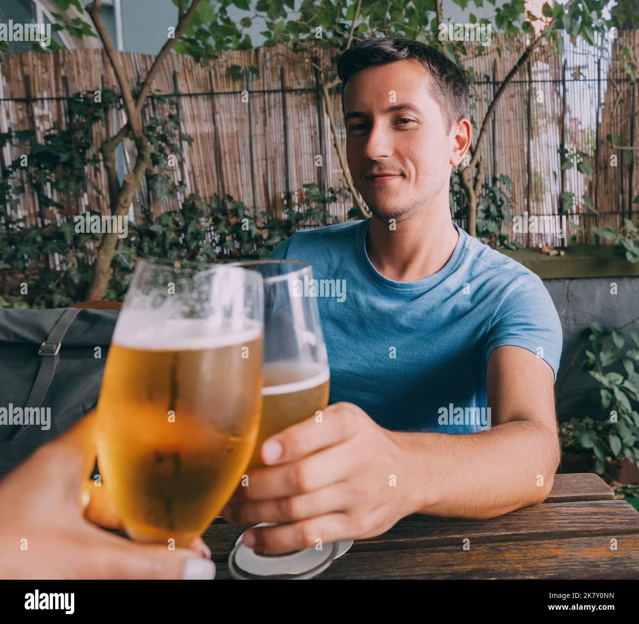 Funny drunk man clink freshly brewed light beer glasses in a bar or pub ...