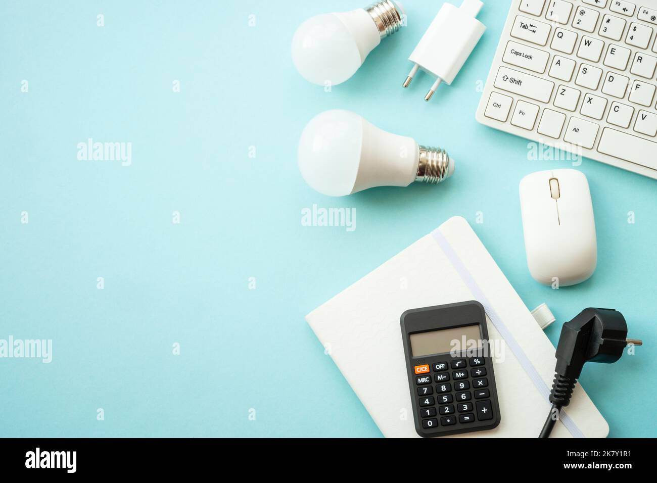 Saving electricity. LED lamp, wire with plug and laptop Stock Photo - Alamy