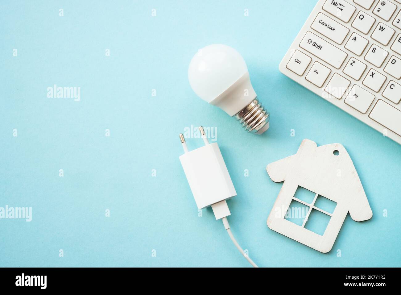 Saving electricity. LED lamp, wire with plug and house Stock Photo - Alamy