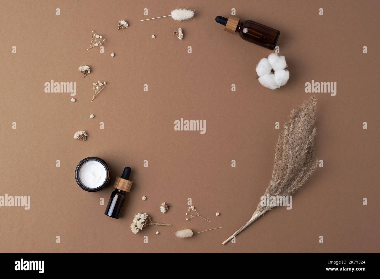 Skin care products on brown background with flowers. Flat lay, copy ...