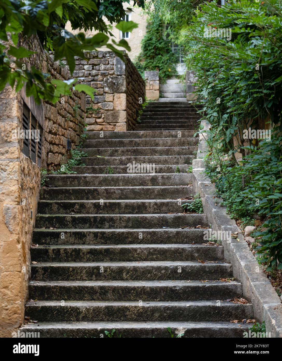 pathway with steps leading up between old stone walls and buildings ...