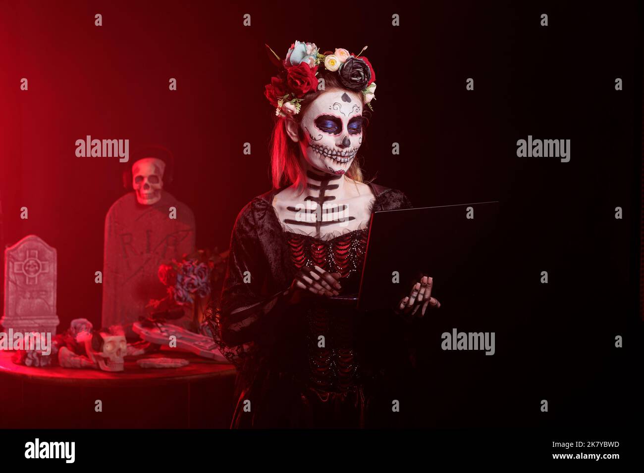 Halloween model using laptop in studio, looking like lady of the holy ...