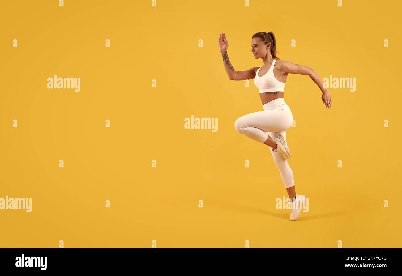 fitness woman runner running on yellow background with copy space Stock ...