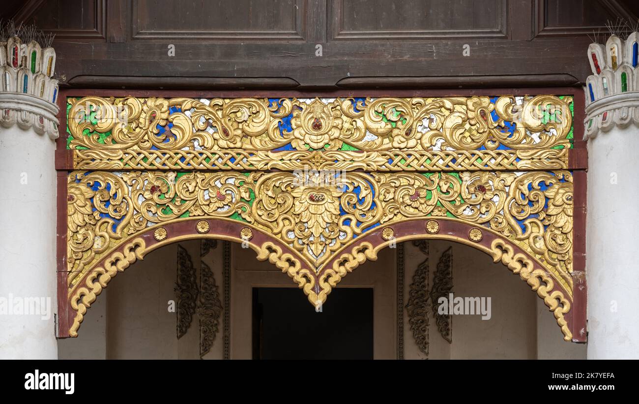 Gilded wood carving panel above entrance of religious building in ...
