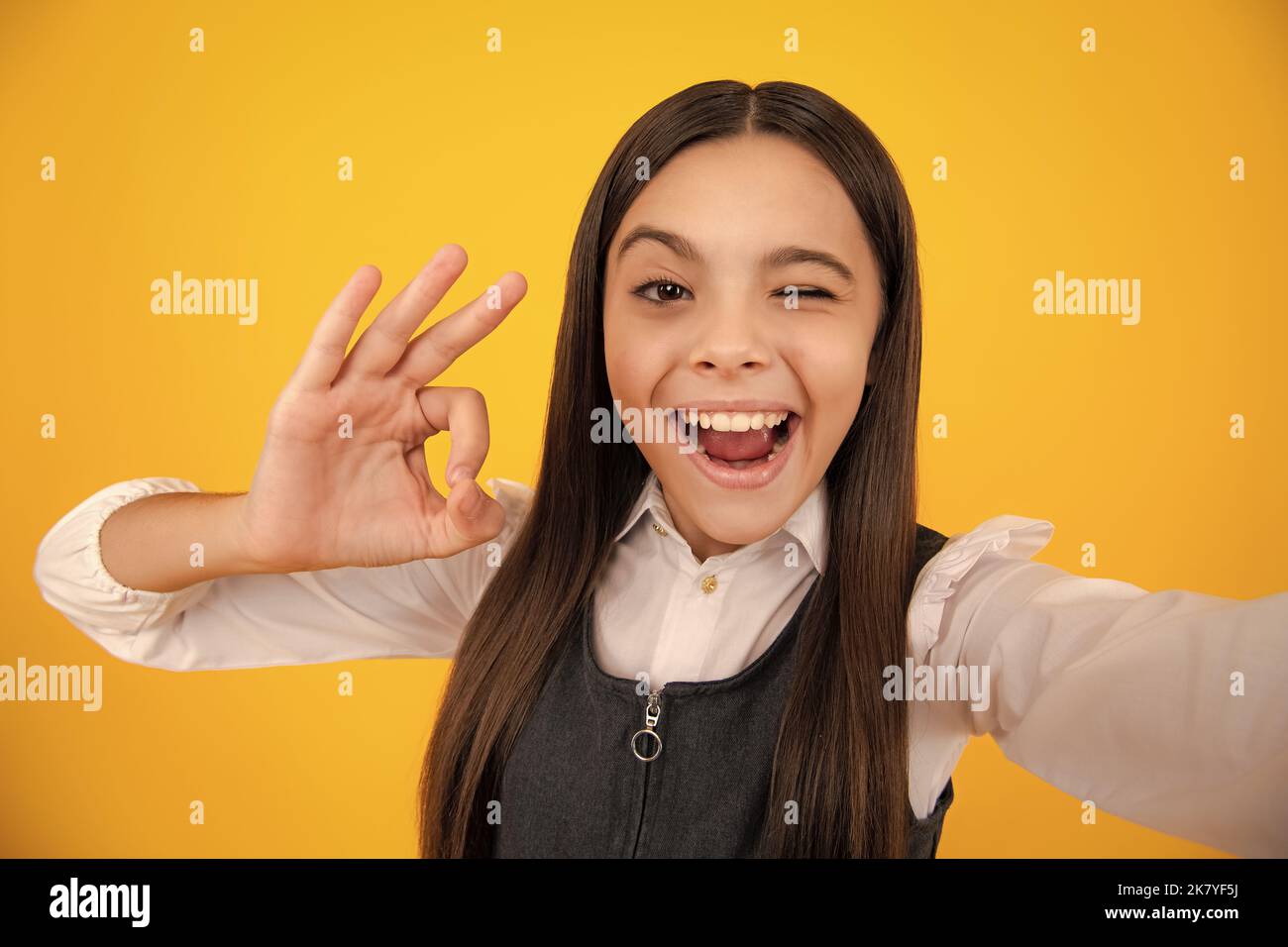 Fashion teen girl in trendy wear making selfie posing on yellow ...