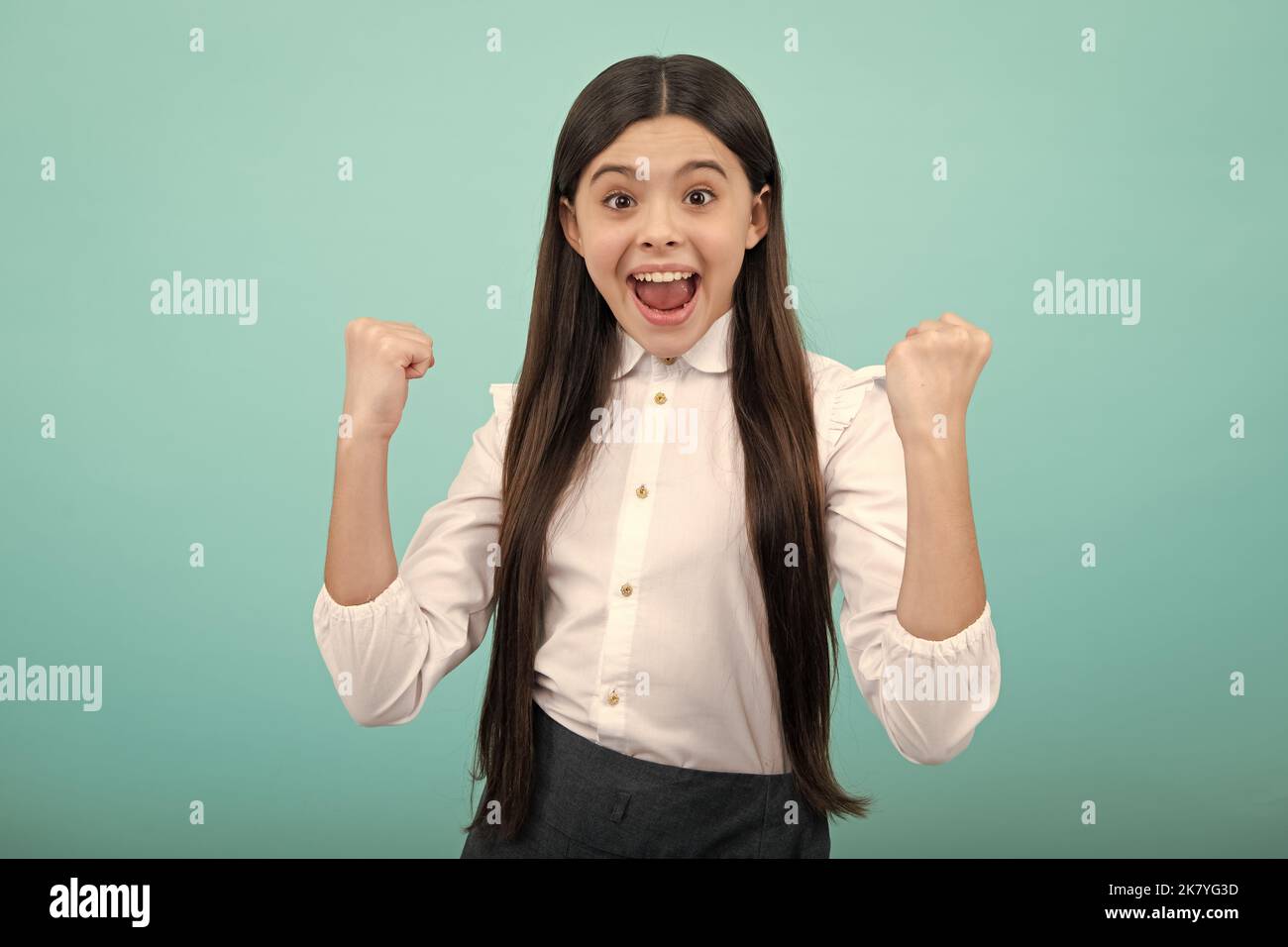 Studio portrait of teenager child doing winner gesture. Kid rejoicing ...