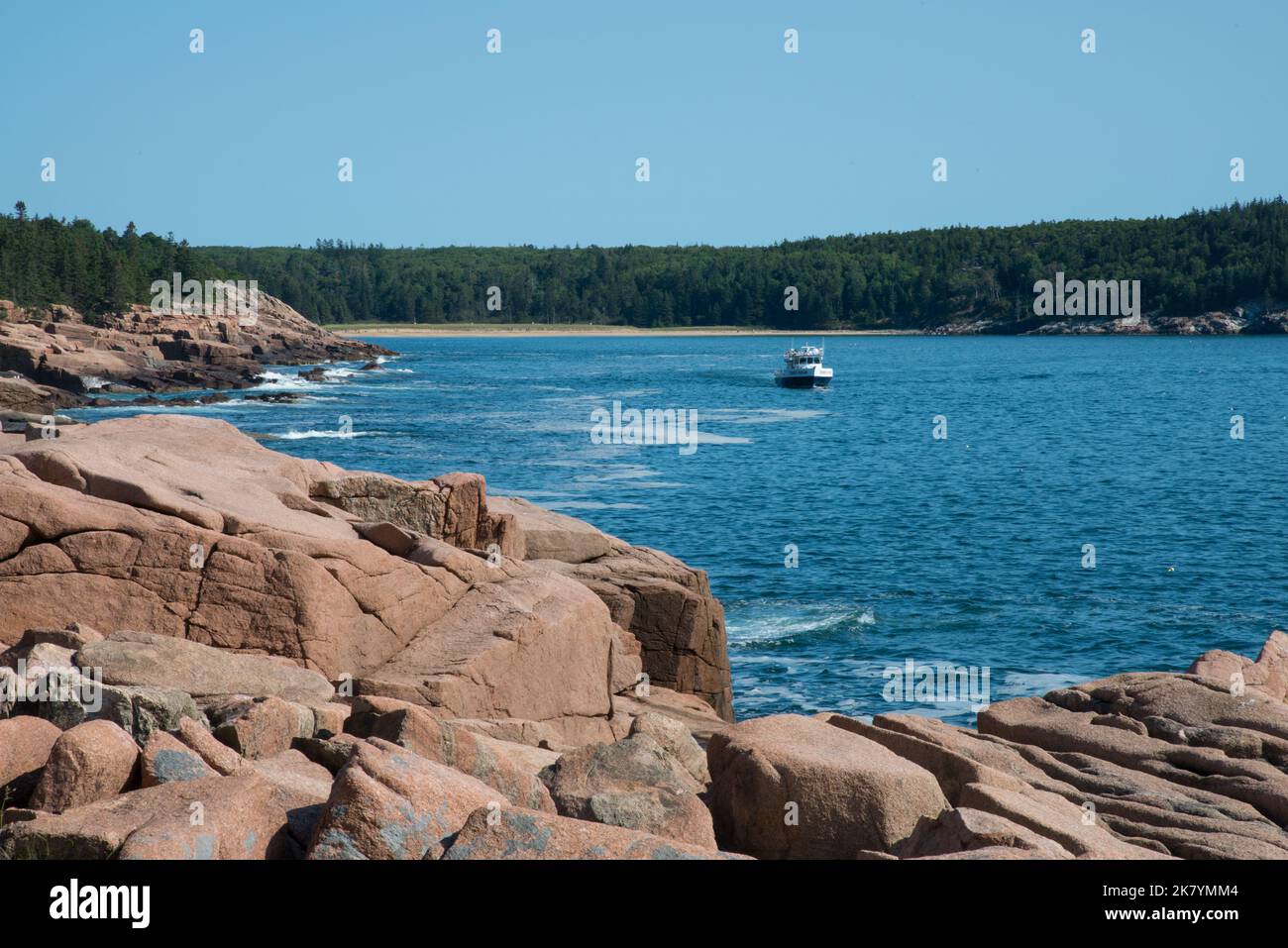 A tour boat makes its way past Sand Beach and Thunder Hole along the ...