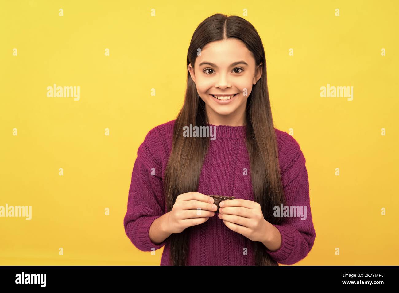 Happy sweet-tooth kid smile holding sweet snack in hands yellow ...