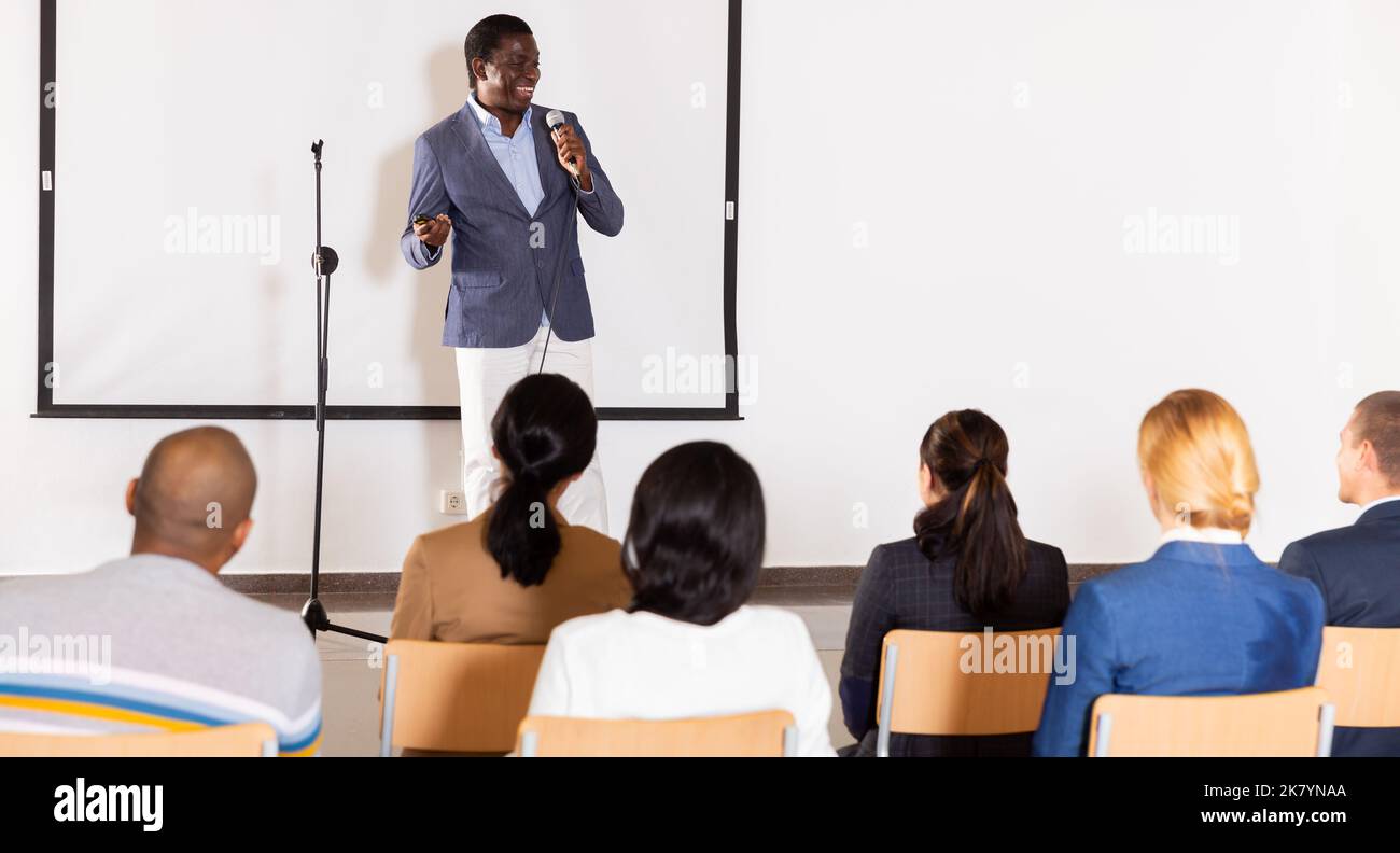 Male coach giving speech at conference hall Stock Photo - Alamy