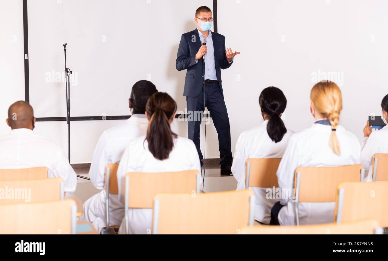 Male coach giving speech at conference hall Stock Photo - Alamy