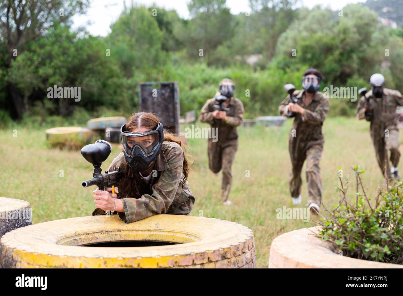 Team of friends paintball players playing together in battle Stock ...